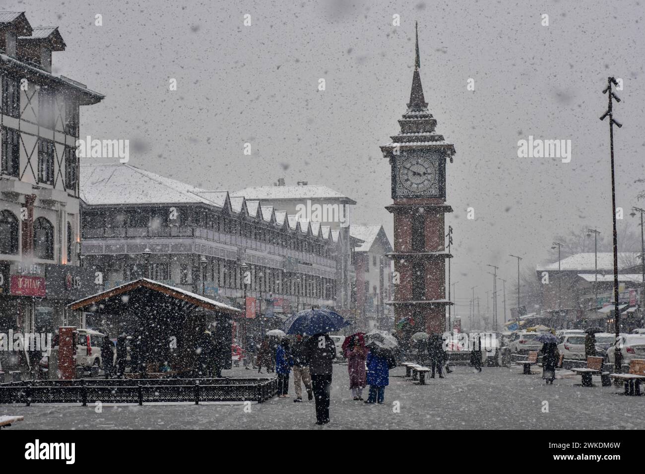 Commuters walk through the street during heavy snowfall in Srinagar ...
