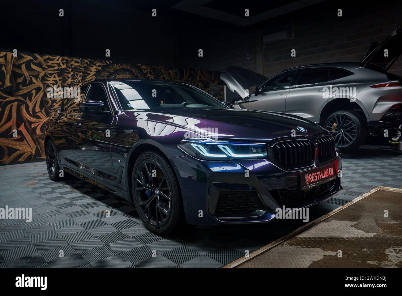 Black BMW Sedan sits in a Luxury Tuning Garage, adorned with Artistic ...