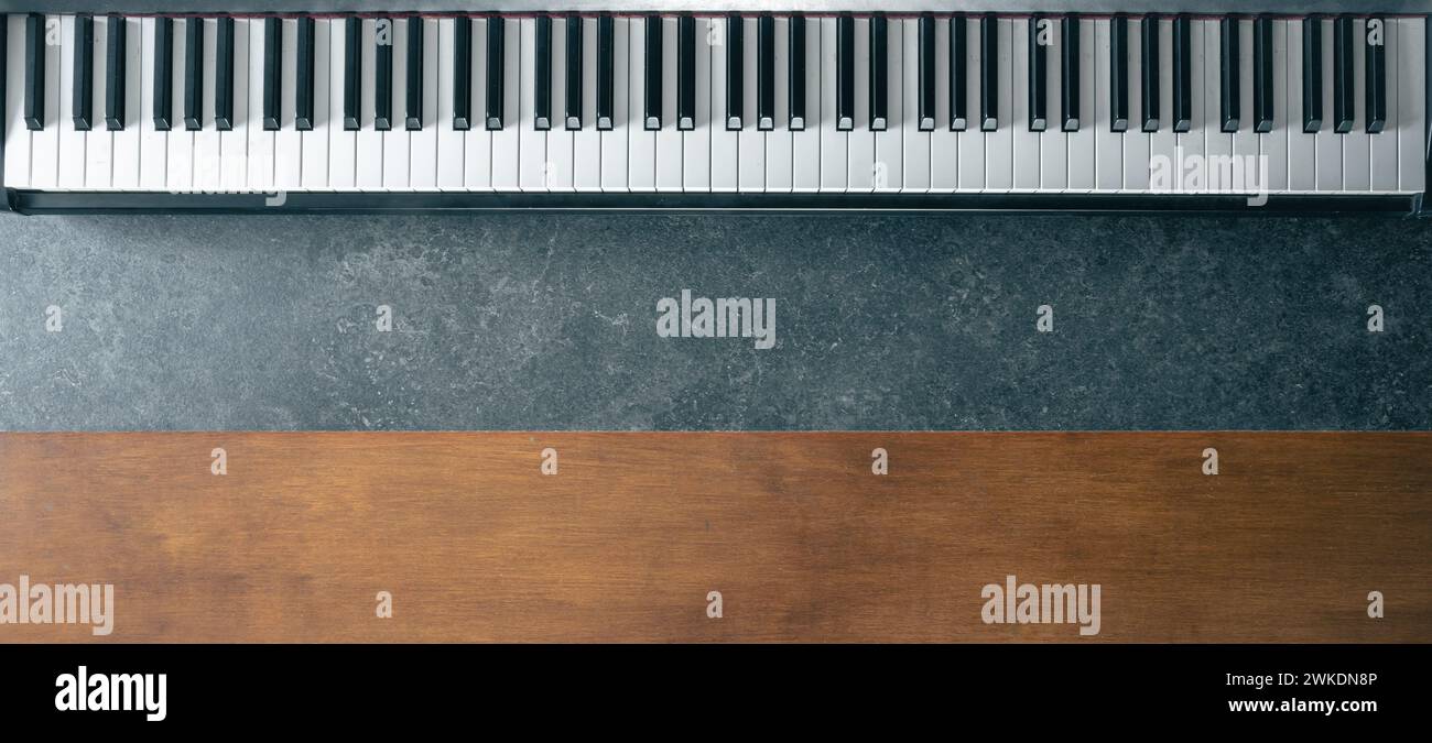 Piano keyboard on a dark marble and wood surface, top view Stock Photo ...