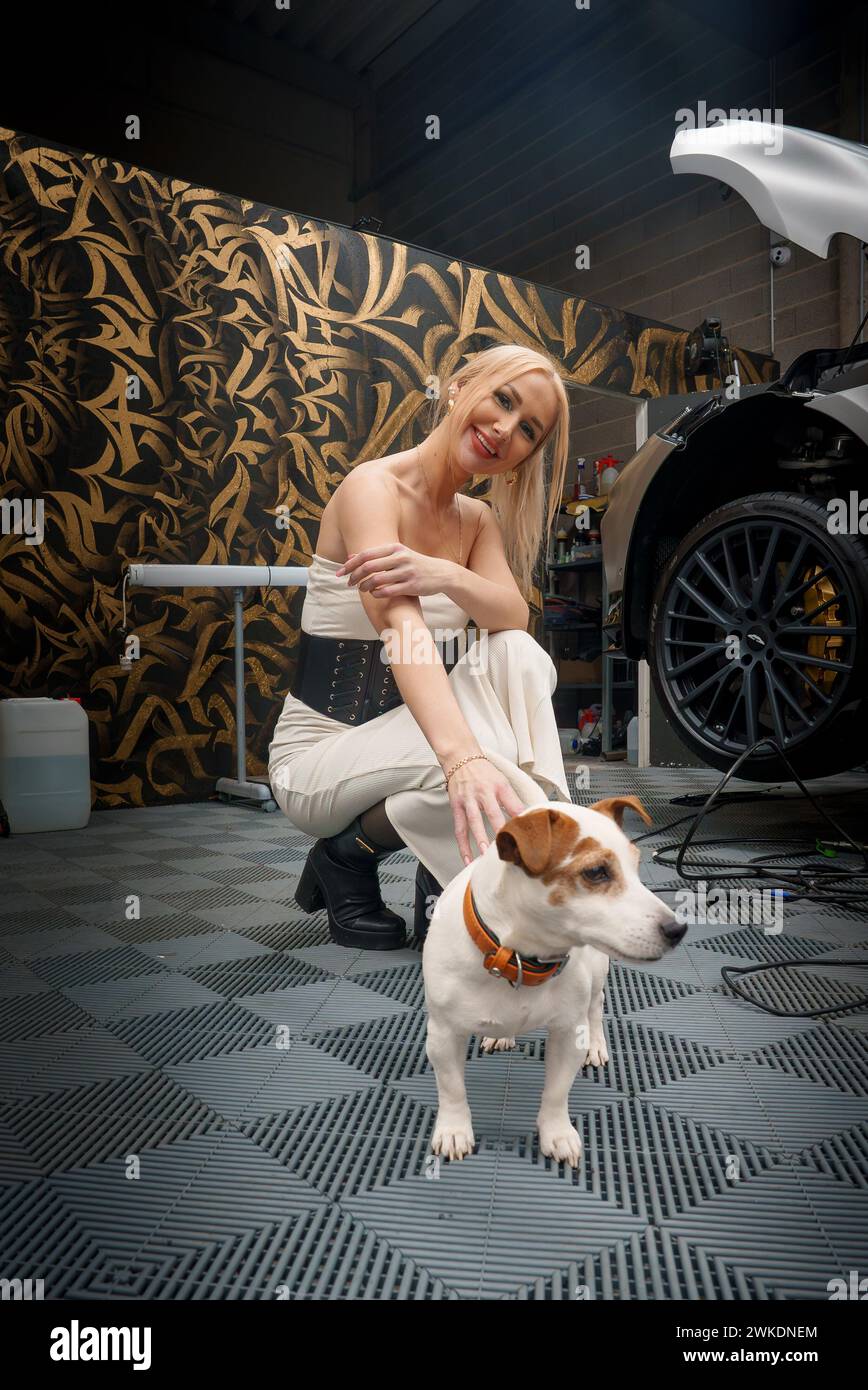 Blonde Lady with Her Dog Inside a Modern, Luxurious Car Tuning Garage ...