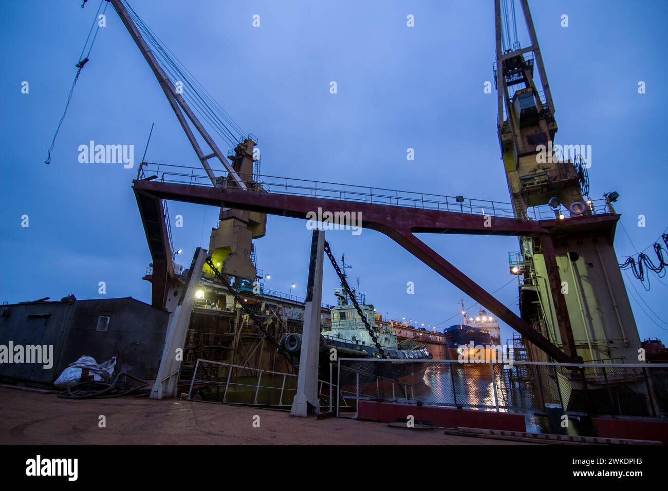 Industrial shipyard at night, floating dock with a ship under repair ...