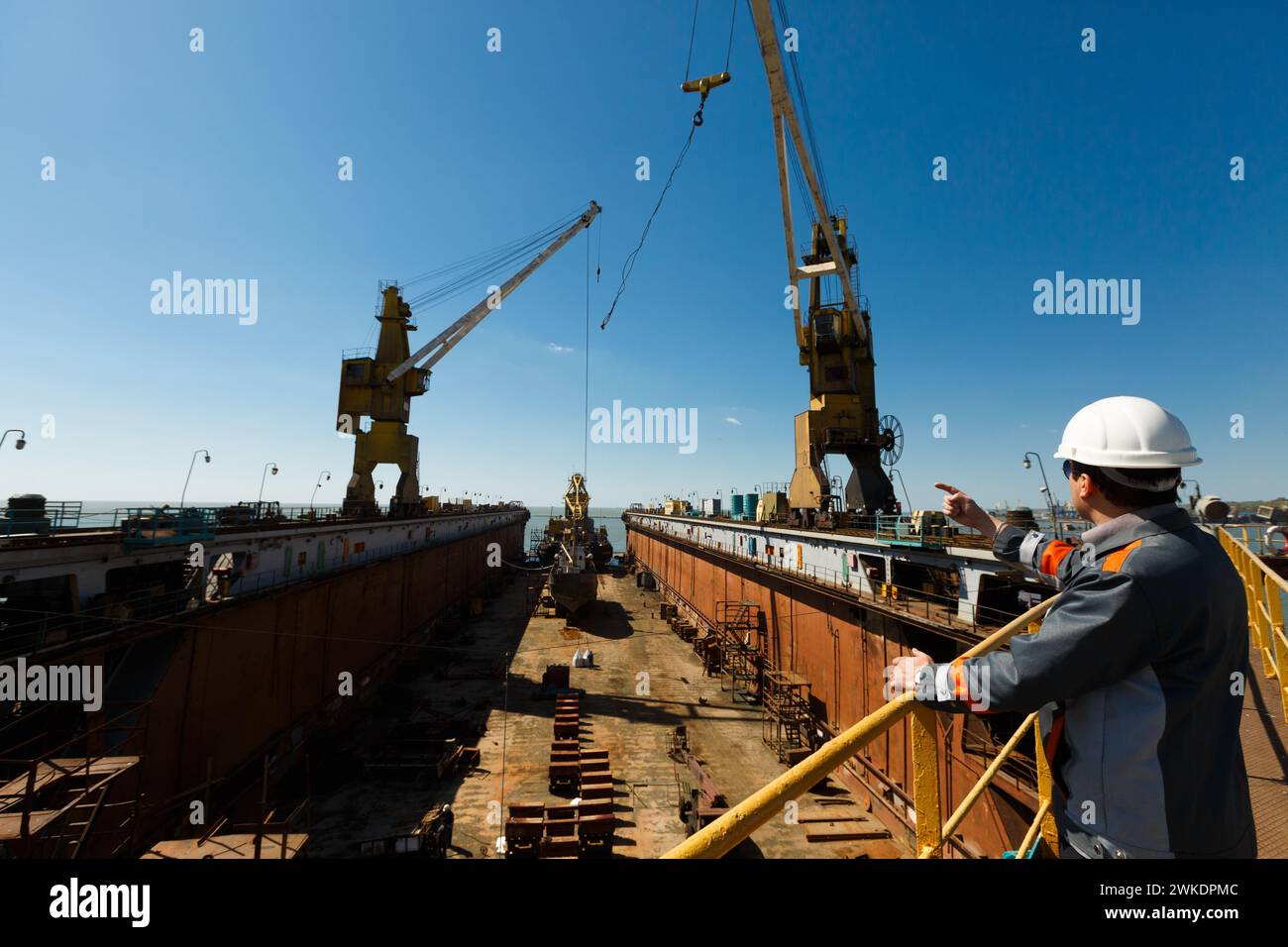 Engineer oversees vessel maintenance in dry dock. Maritime worker ...