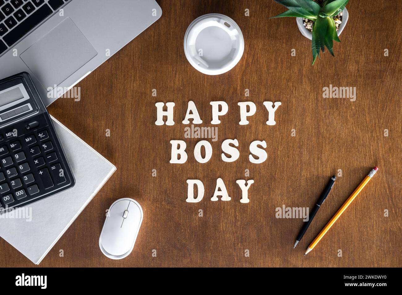 Wooden inscription Happy Boss Day on a wooden office desk background ...