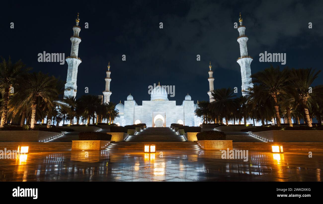 Amazing beautiful mosque with palm trees and lights in the night city ...