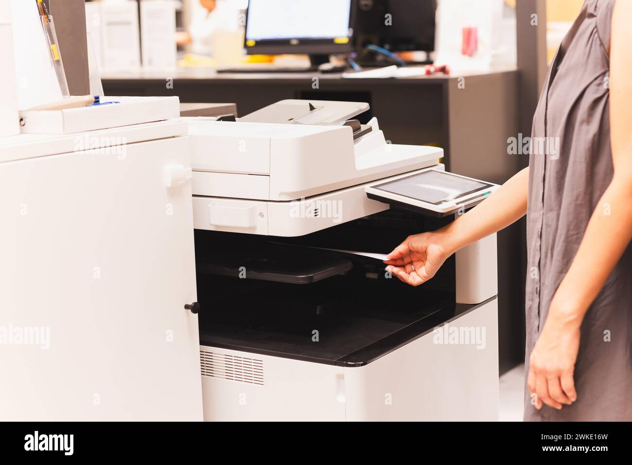 Woman officer pull printing paper document out from functional office ...