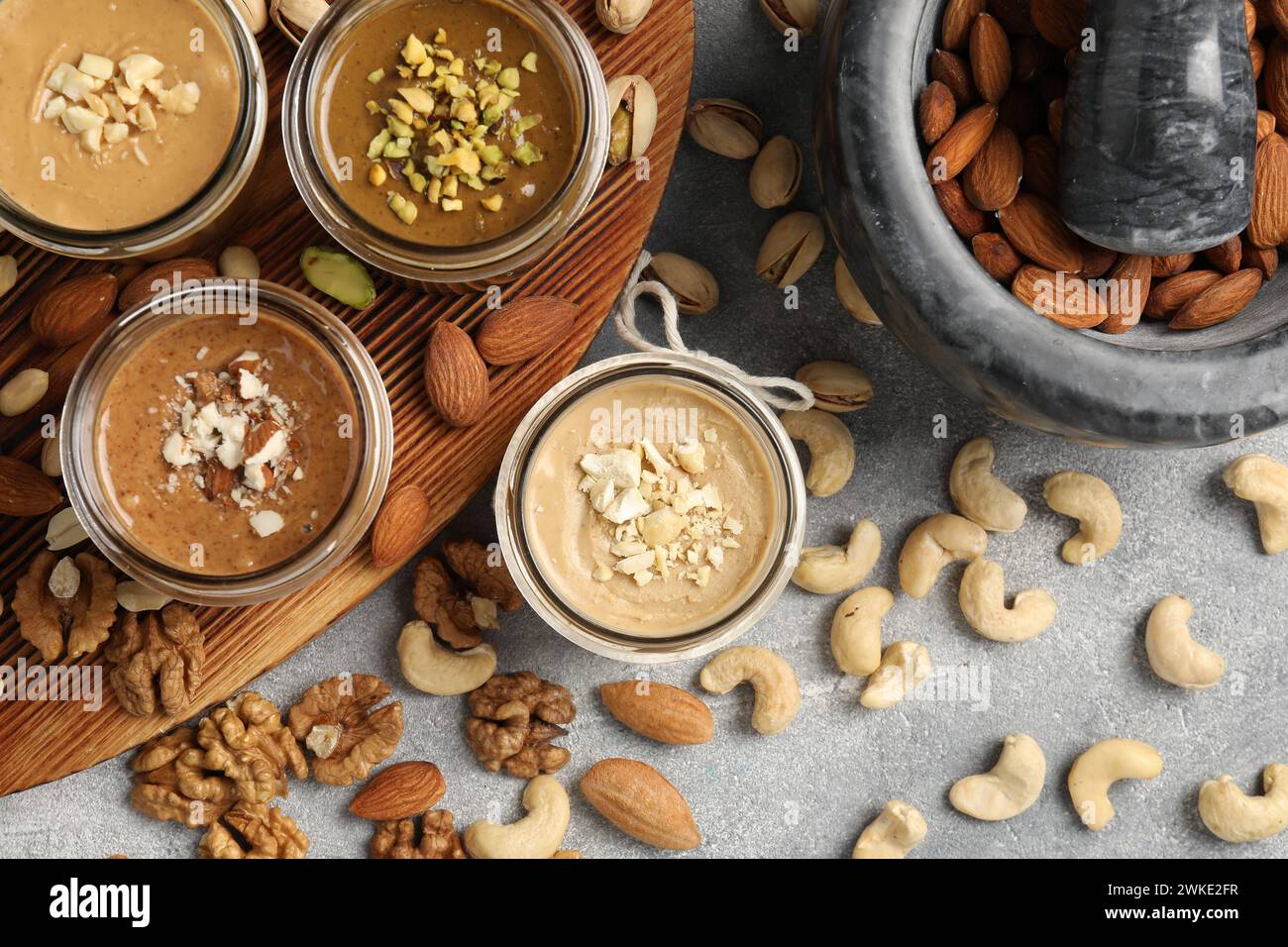 Making nut butters from different nuts. Flat lay composition on light ...