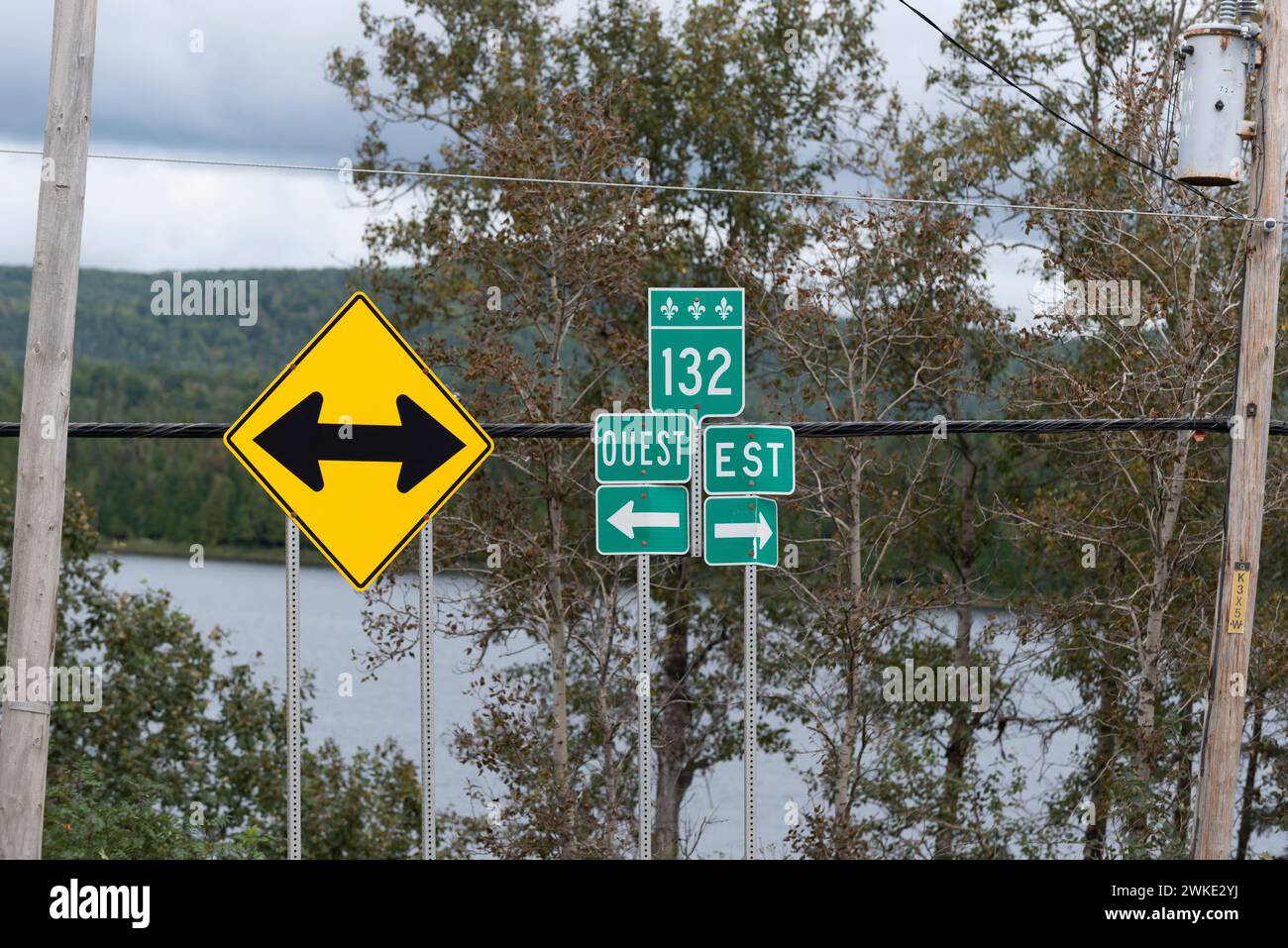 The photo shows road signs with the cardinal points east and west ...