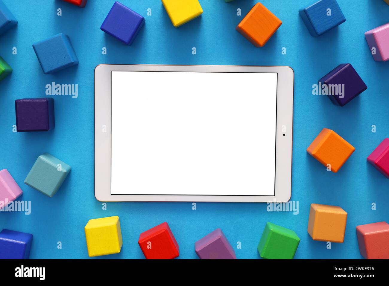 Modern tablet and cubes on light blue background, flat lay. Space for ...