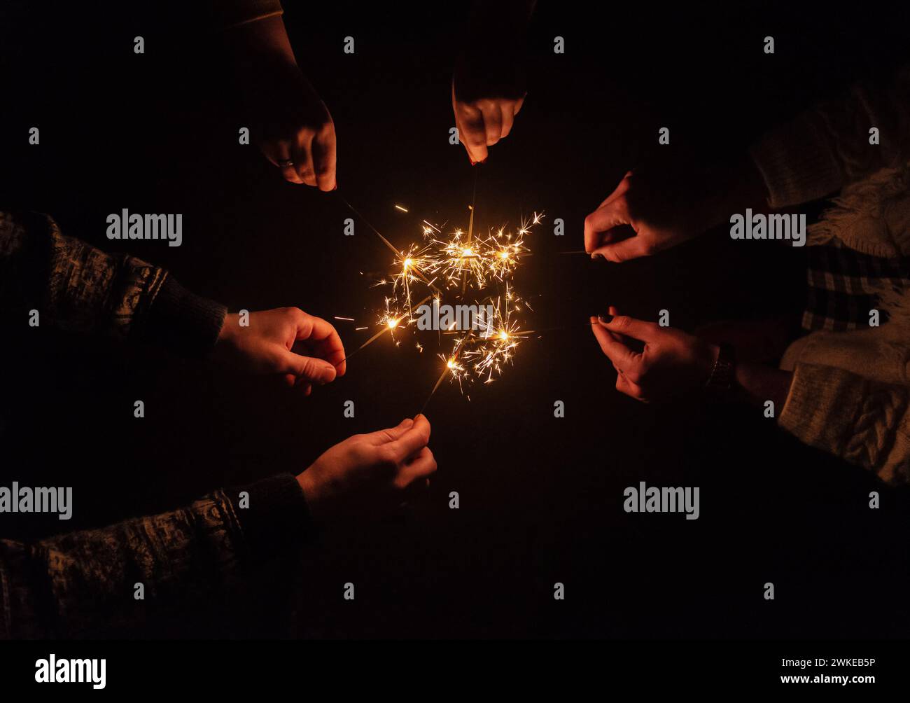 Group of friends holding burning sparklers in hands. Flames of Bengal ...