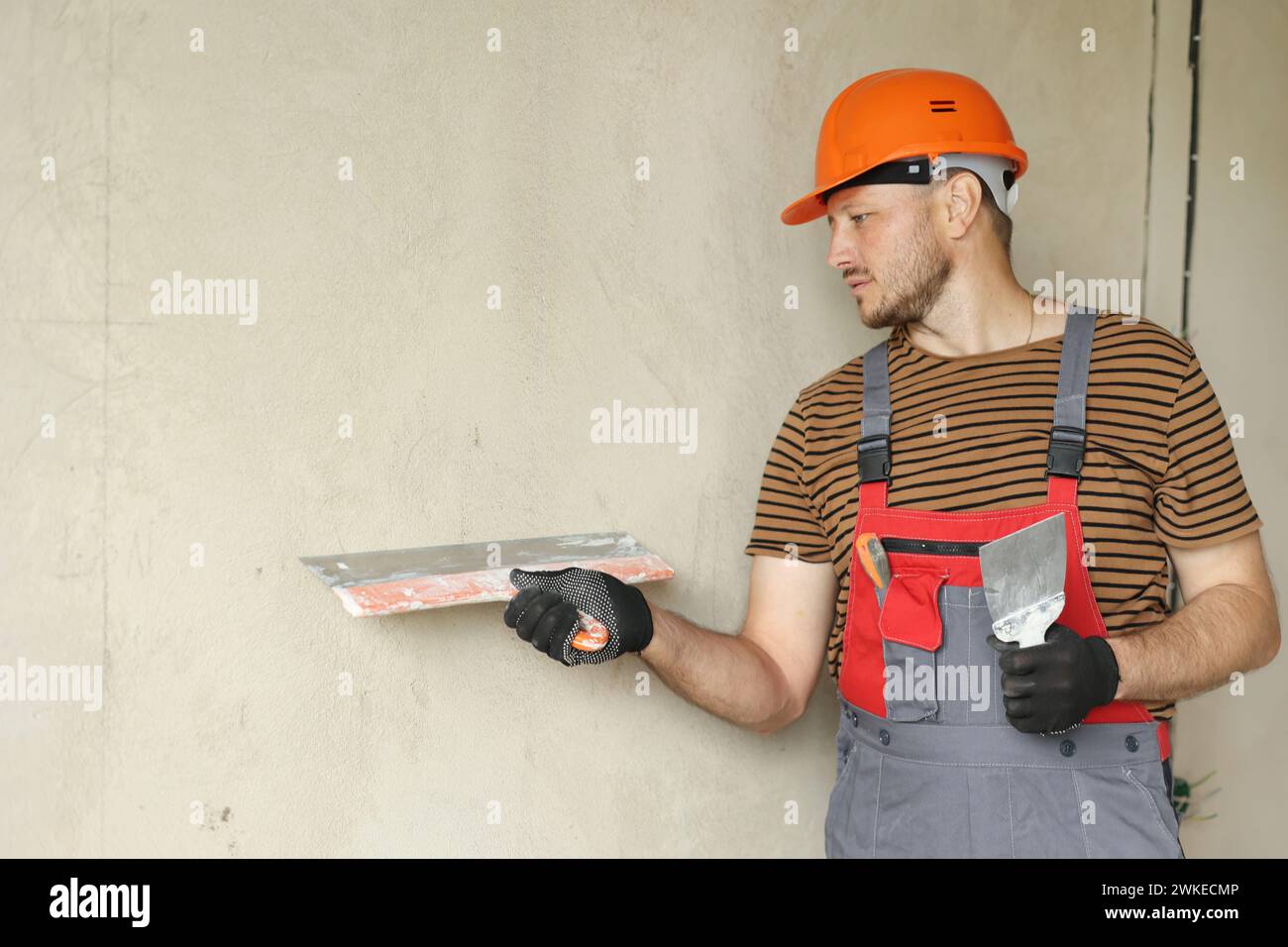 Rear view of handyman worker in overalls and protective helmet ...