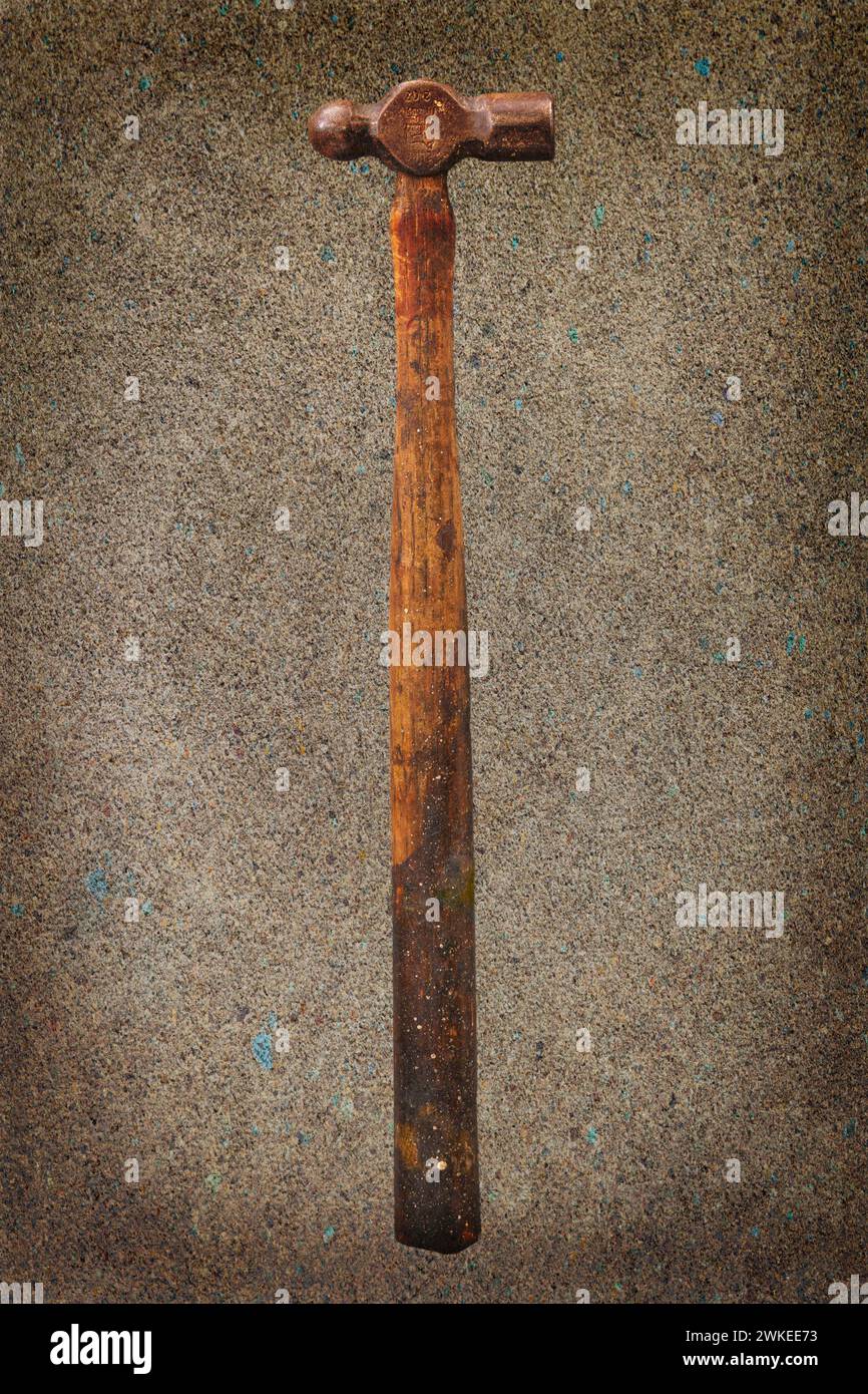 A small, slightly rusty ball peen hammer proudly wears its decades old ...