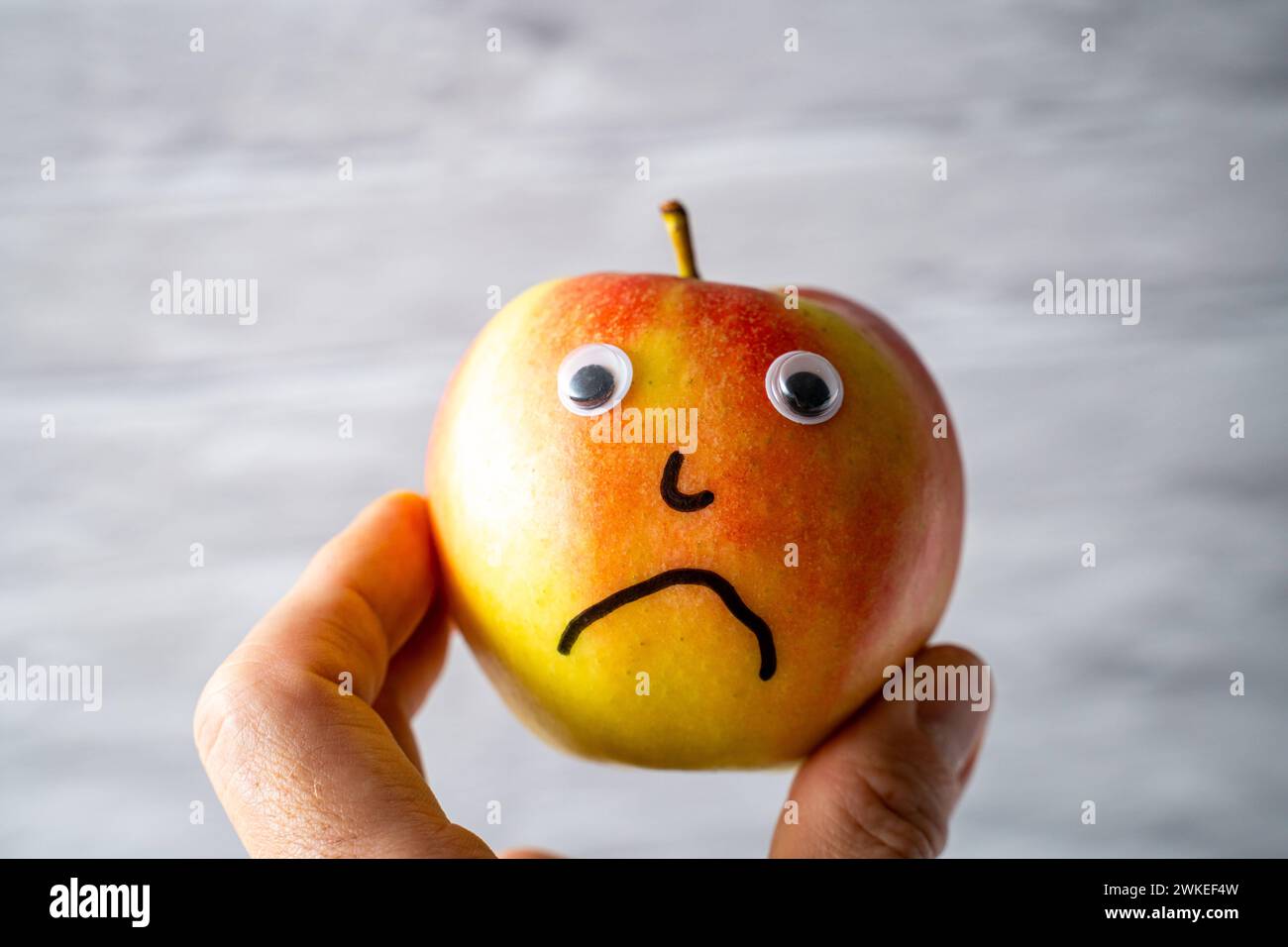 Augsburg, Bavaria, Germany - February 18, 2024: A man holds an apple ...