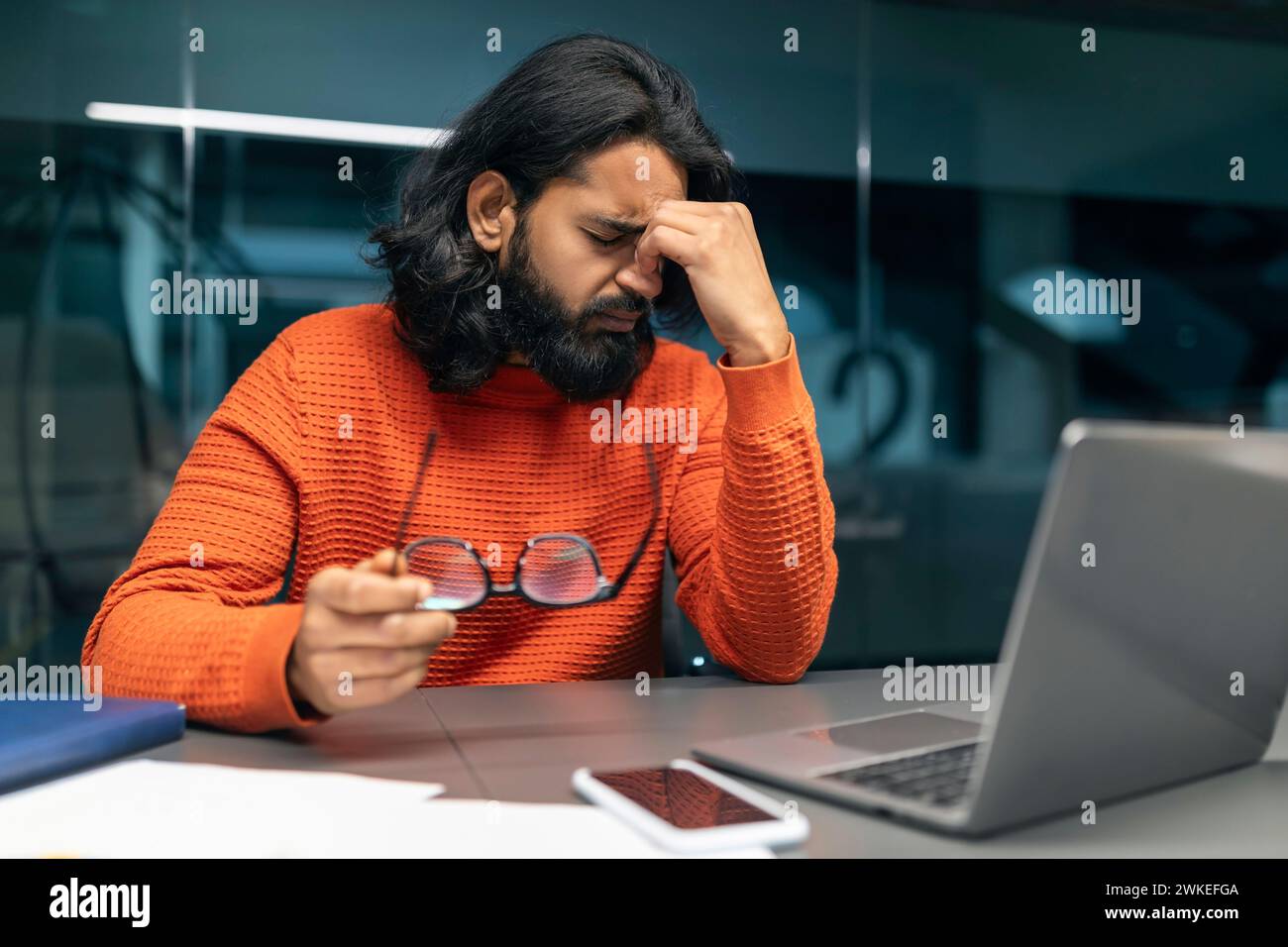 Tired indian man sitting in front of computer at office Stock Photo - Alamy