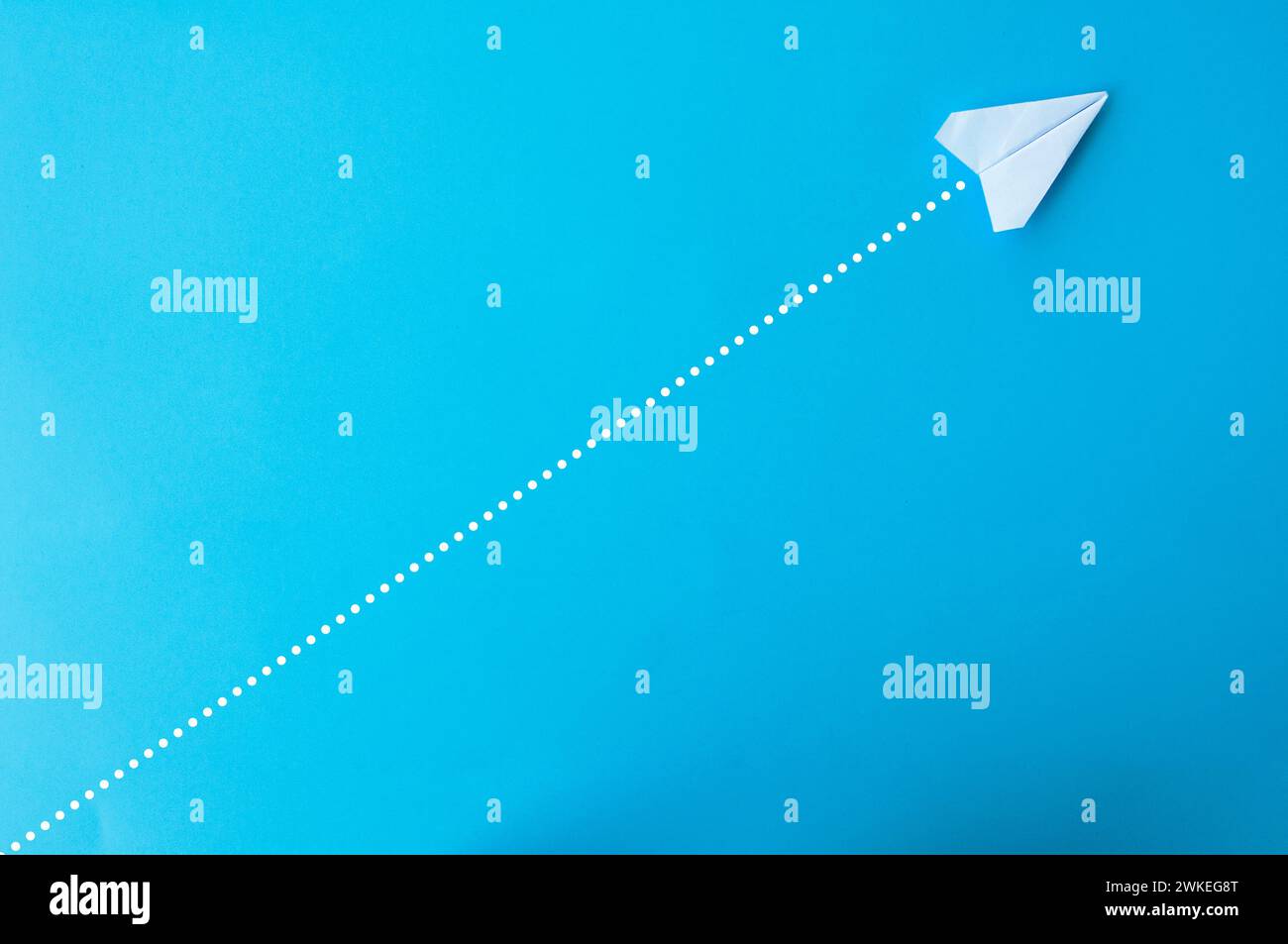 Top view of paper airplane with straight line dots on blue background ...