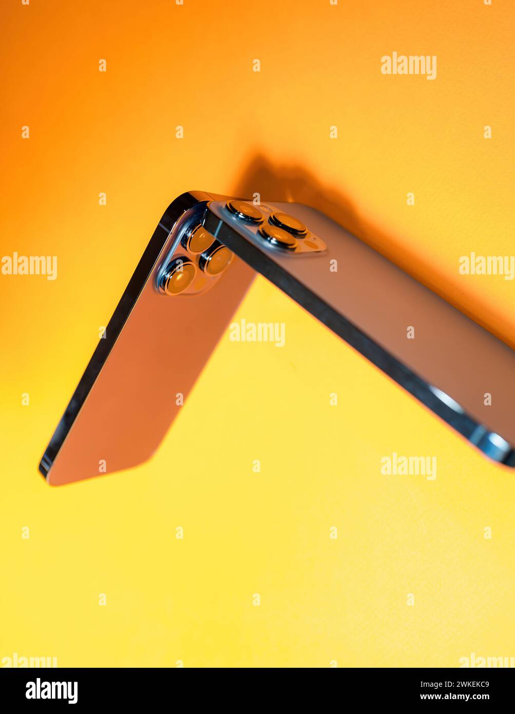 Two mobile smartphones featuring triple cameras each, set against a ...