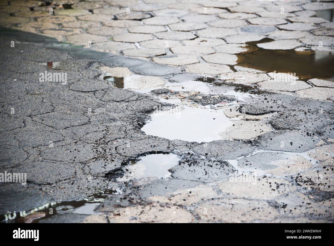 Potholes in the road, a dilapidated asphalt road with rainwater in the ...