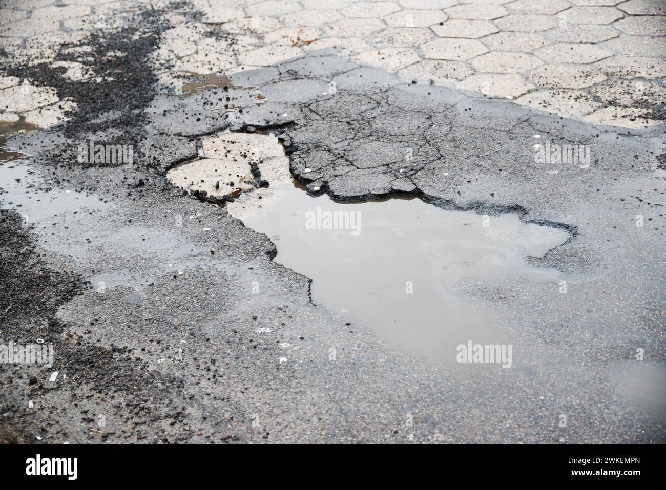 Potholes in the road, a dilapidated asphalt road with rainwater in the ...