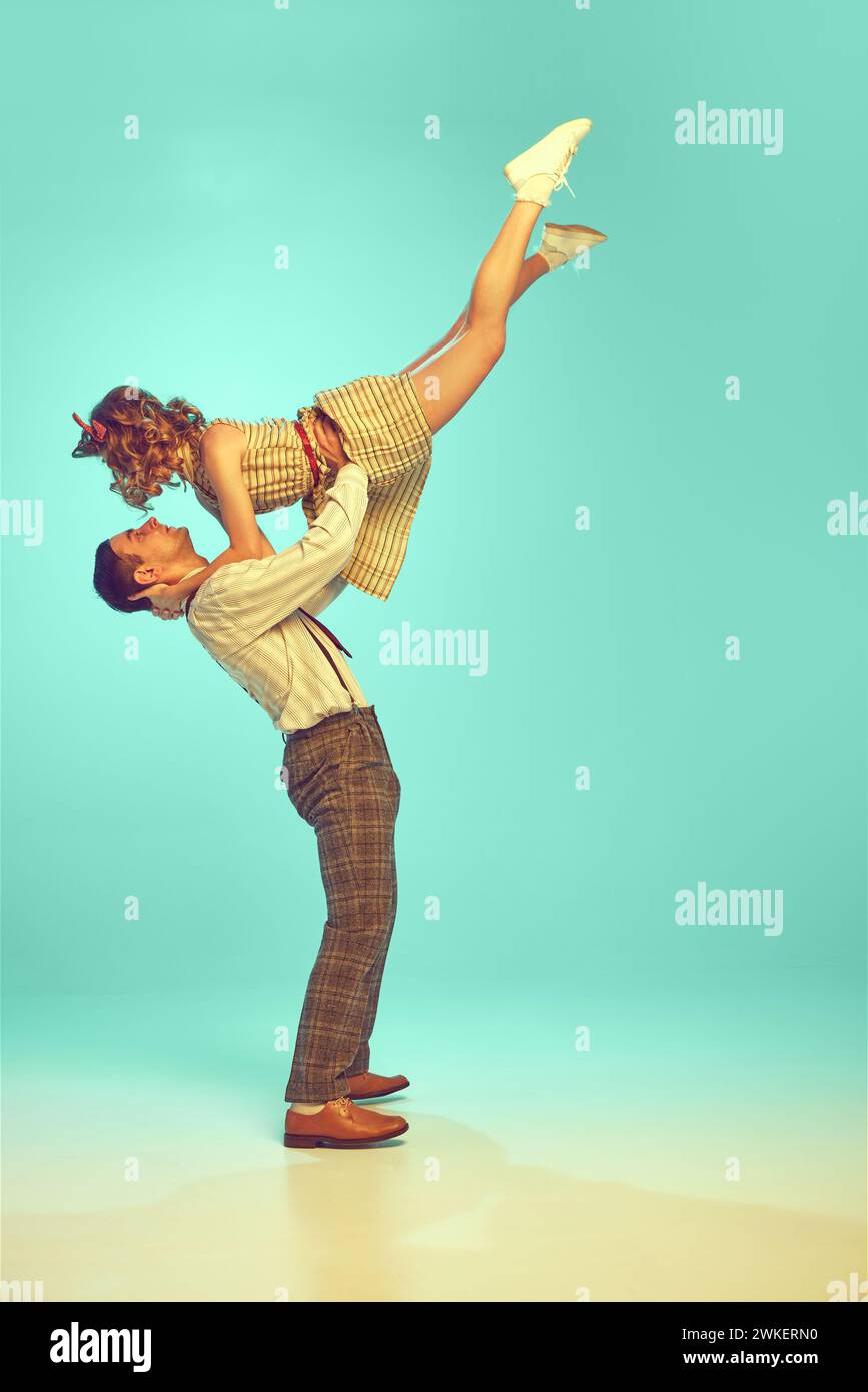 Dynamic portrait of happy couple performing lively swing dance moves in ...