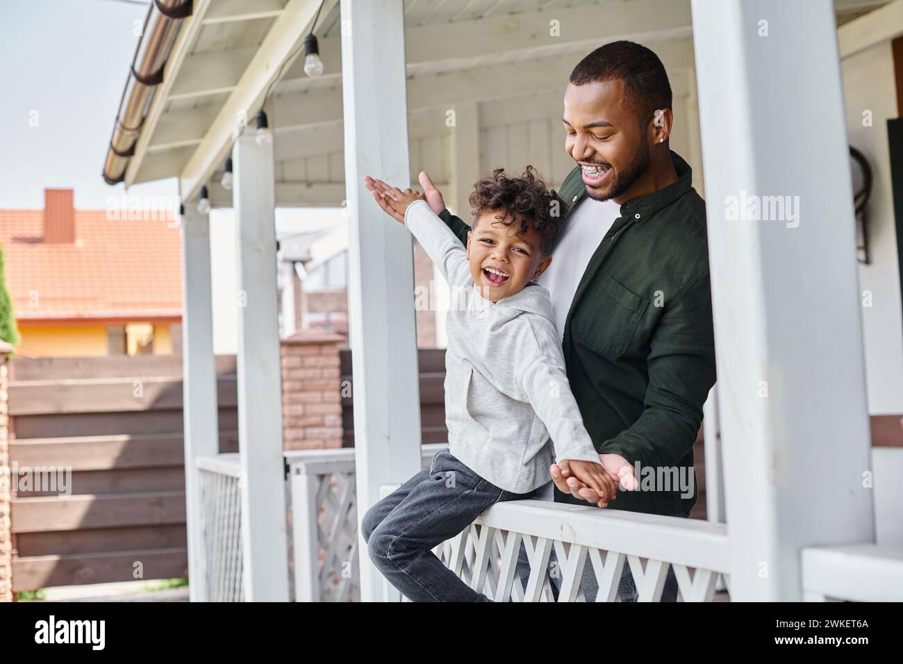 happy moments, african american boy sitting on porch and holding hands ...
