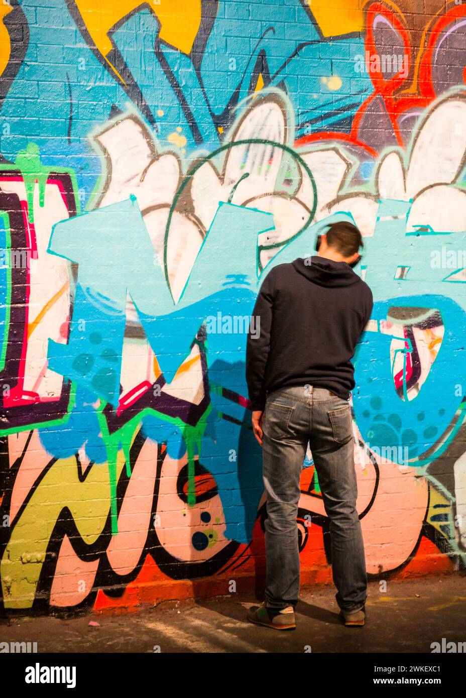 Street artists painting graffiti in the Leake Street Tunnel, London ...