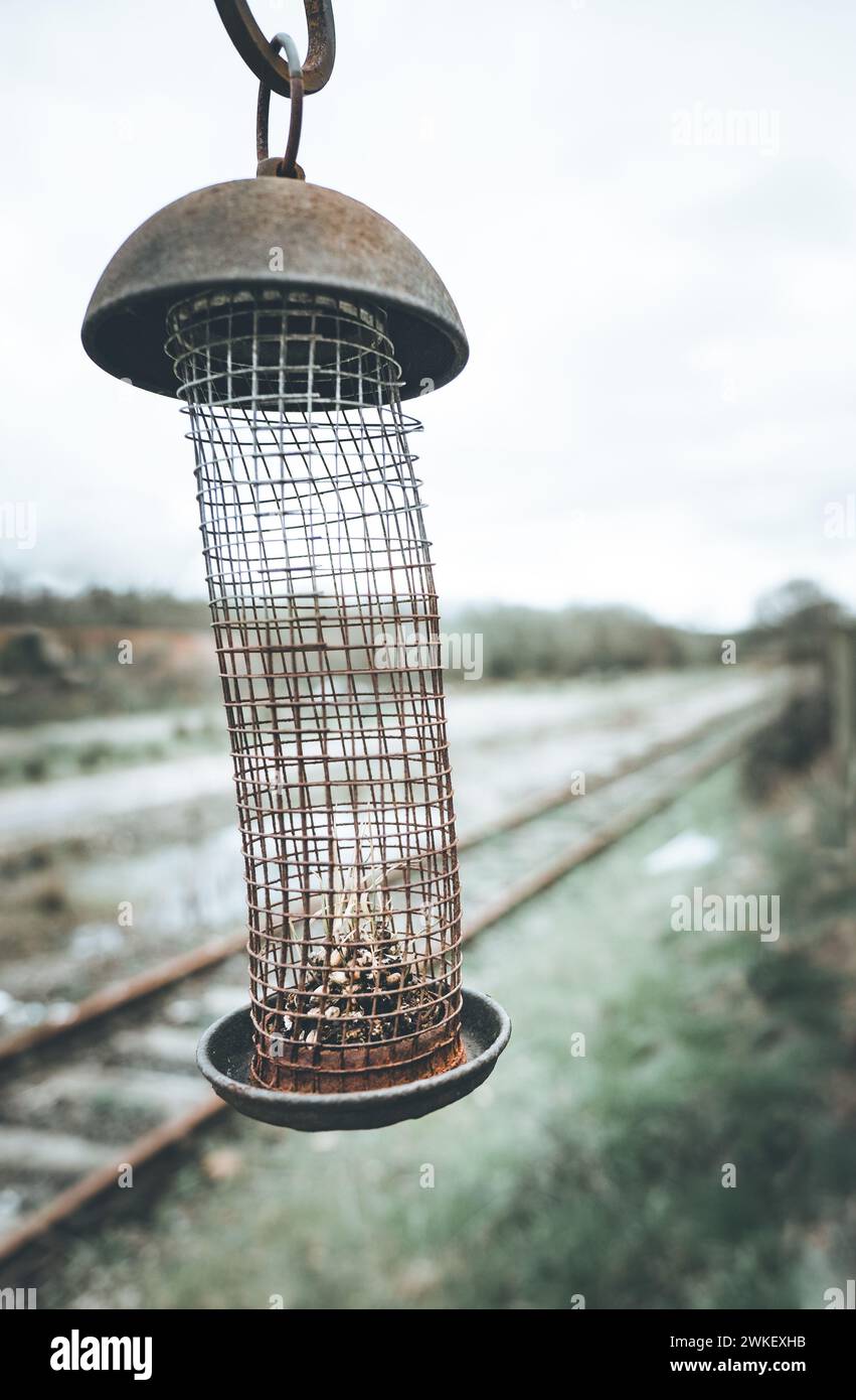 Empty bird feeder overhanging disused train tracks Stock Photo - Alamy