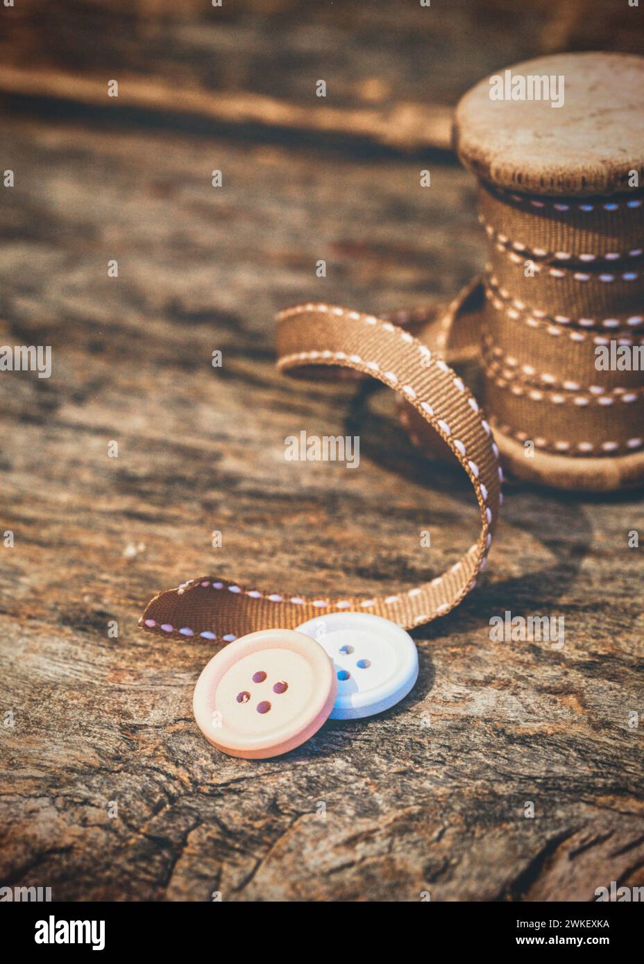 A bobbin of ribbons with a pink and blue button Stock Photo - Alamy