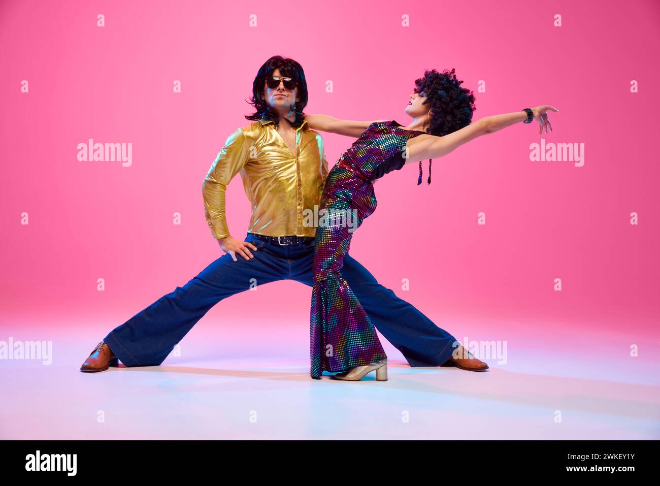 Lost in Rhythm. Young couple, man and woman in bright retro costumes in ...