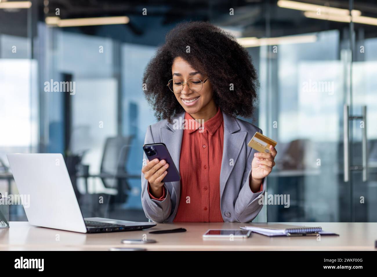 Satisfied african american female keeping debit card and cellular phone ... Satisfied african american female keeping debit card and cellular phone ...