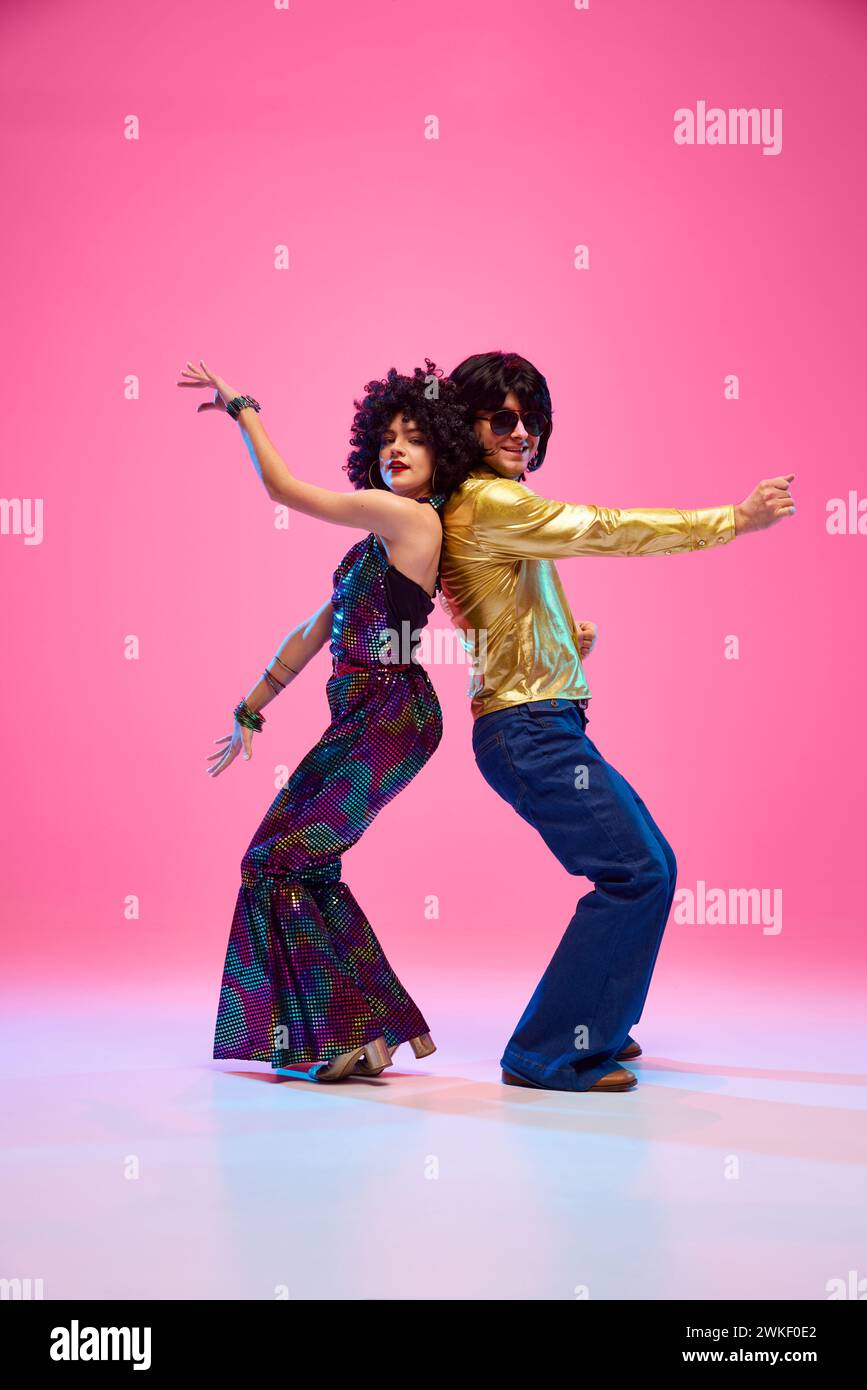 Energetic disco dance lift, couple in 1970s fashion outfit dancing in ...
