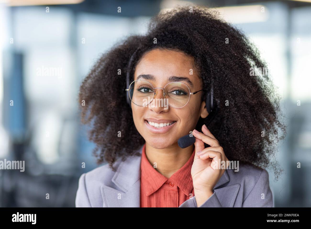 Portrait of black woman with bushy hairstyle fixing microphone on ...