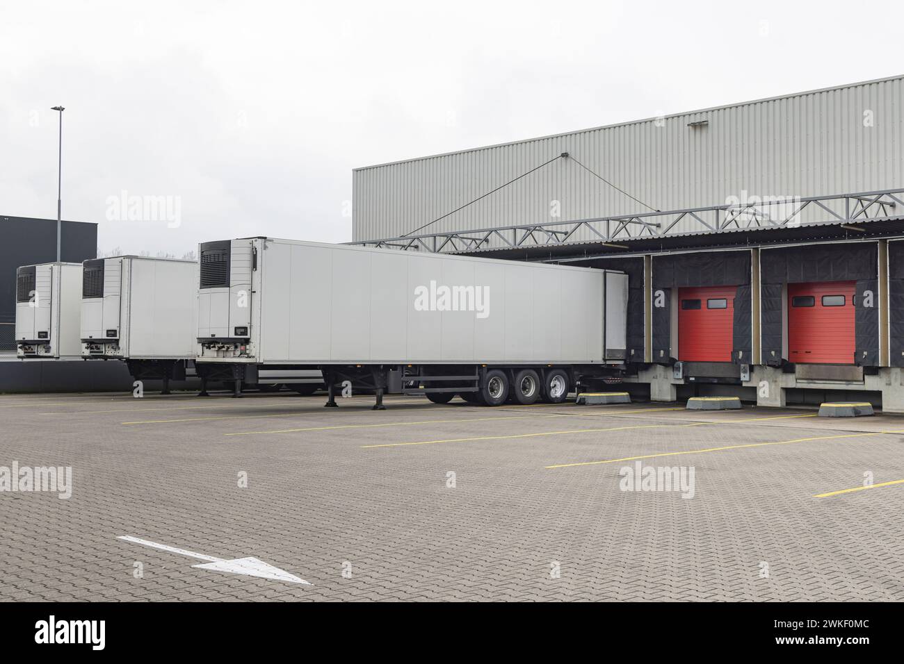 Row of red loading docks with containers of a warehouse or distbution ...