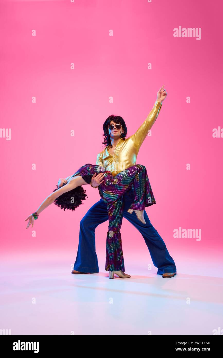 Disco duo mid-dance, man in bell-bottoms lifting partner against ...