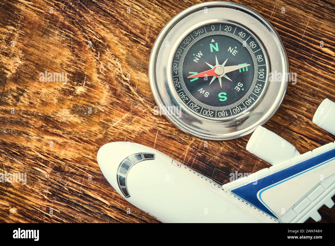 Airplane and compass pointing west. Concept air travel Stock Photo - Alamy