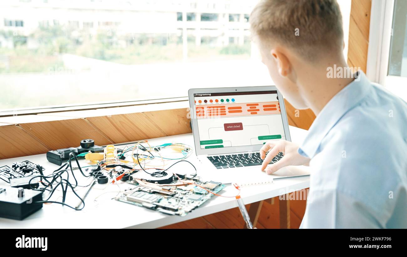 Caucasian student looking at laptop screen while coding engineering ...