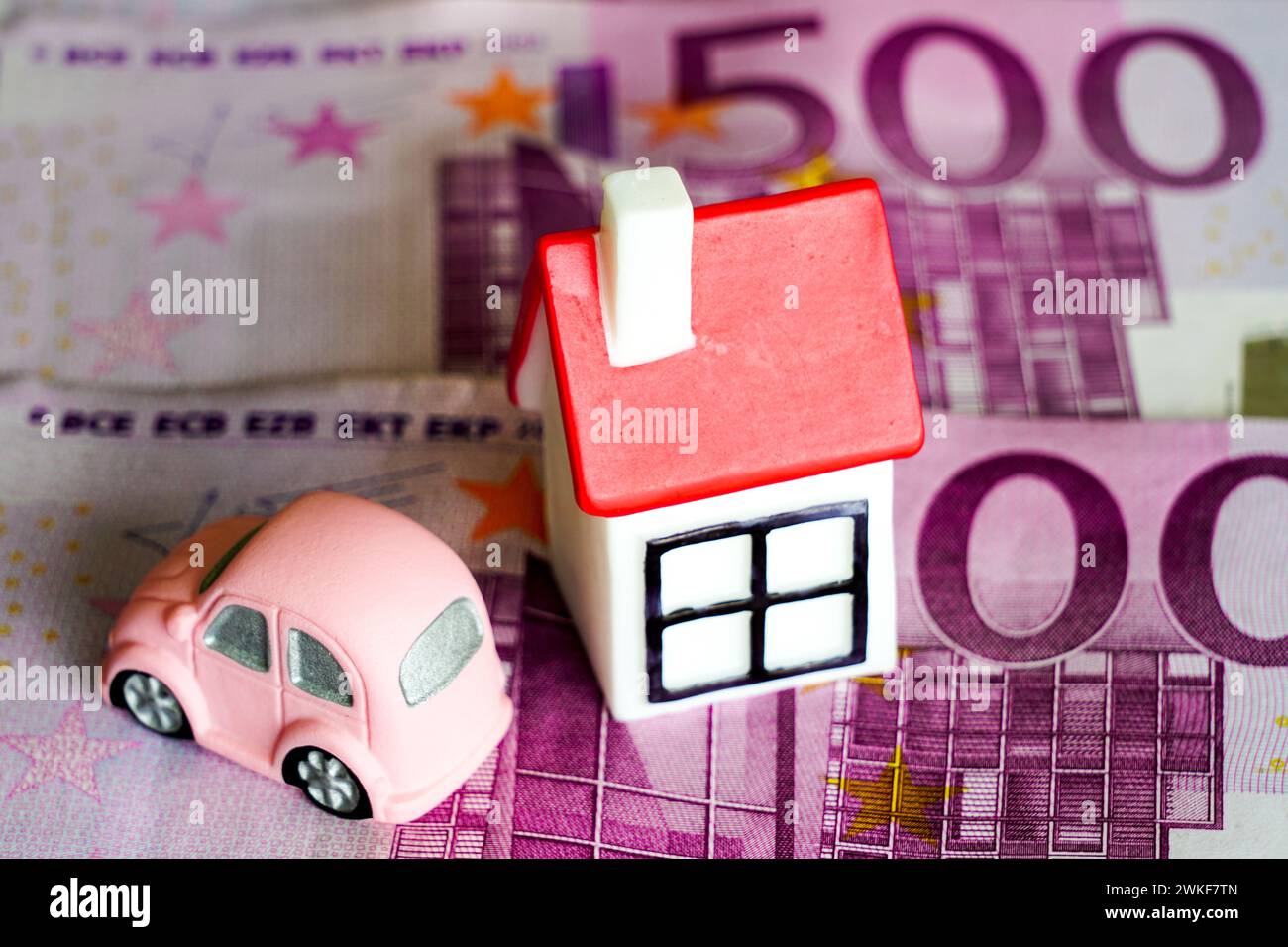 Small white toy house with red roof and small pink car on 500 euro ...