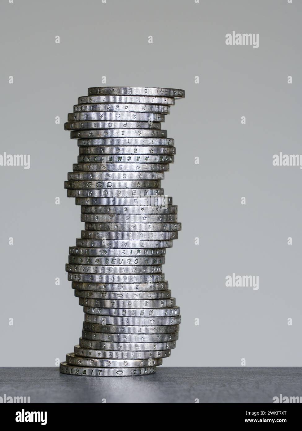 Unstable coins stack of two euro coins on a grey background, future ...