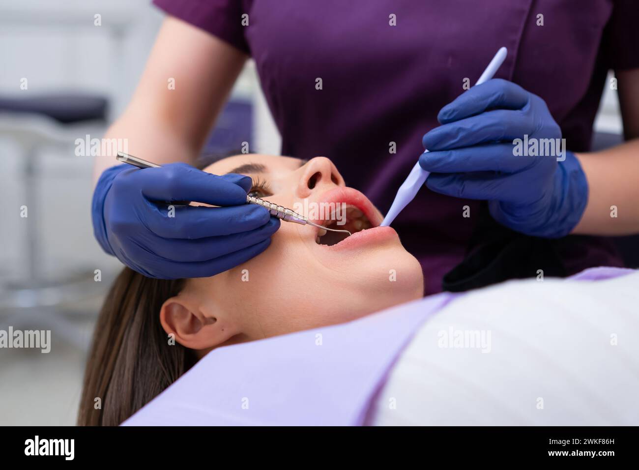 A dentist is inspecting a patients teeth during an appointment at the ...