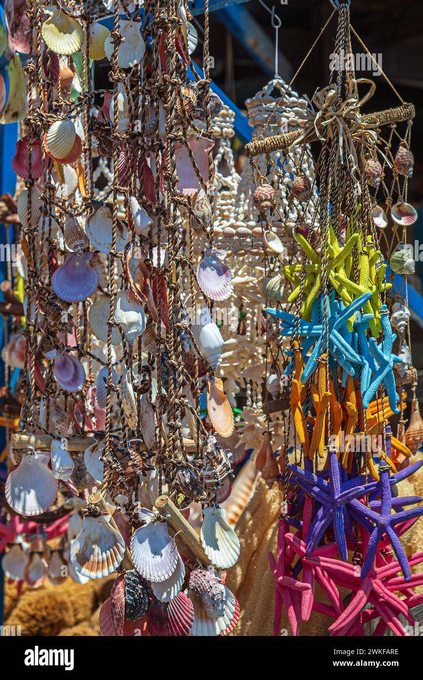 Background with ornamental shells and souvenirs hanging from a net on a ...