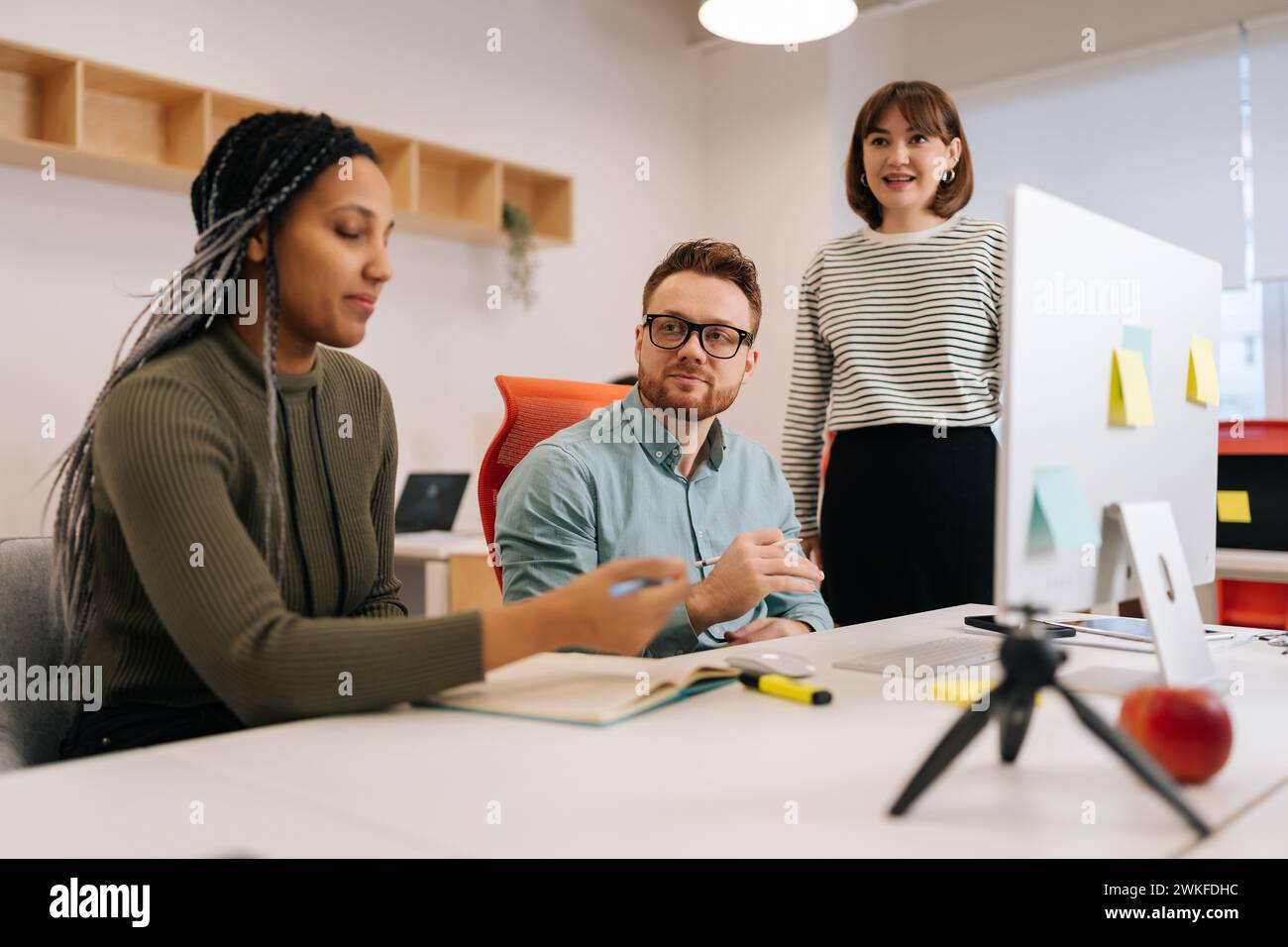 Diverse three colleagues working together discussing computer project ...