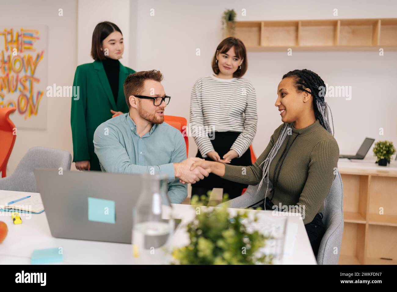 Happy business people handshaking, clapping hands for success at ...