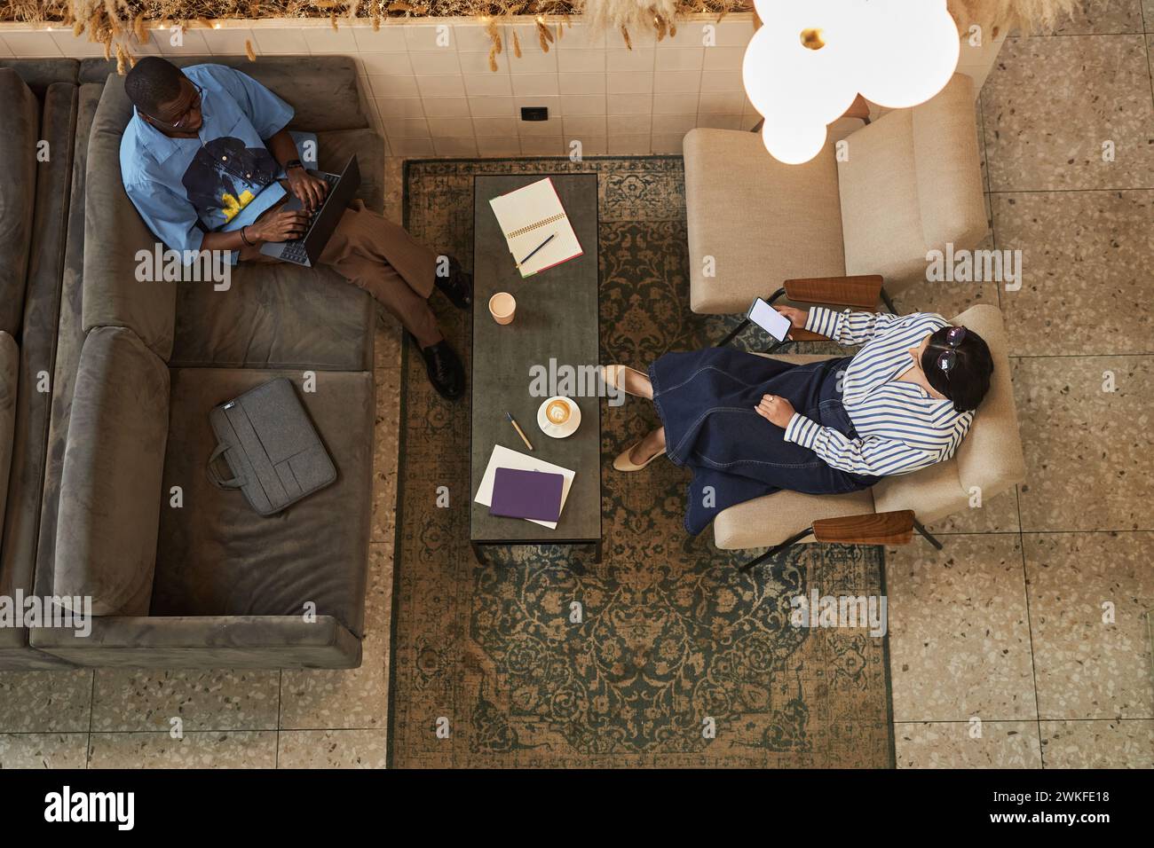 Top view at two business people sitting on opposite couches and ...