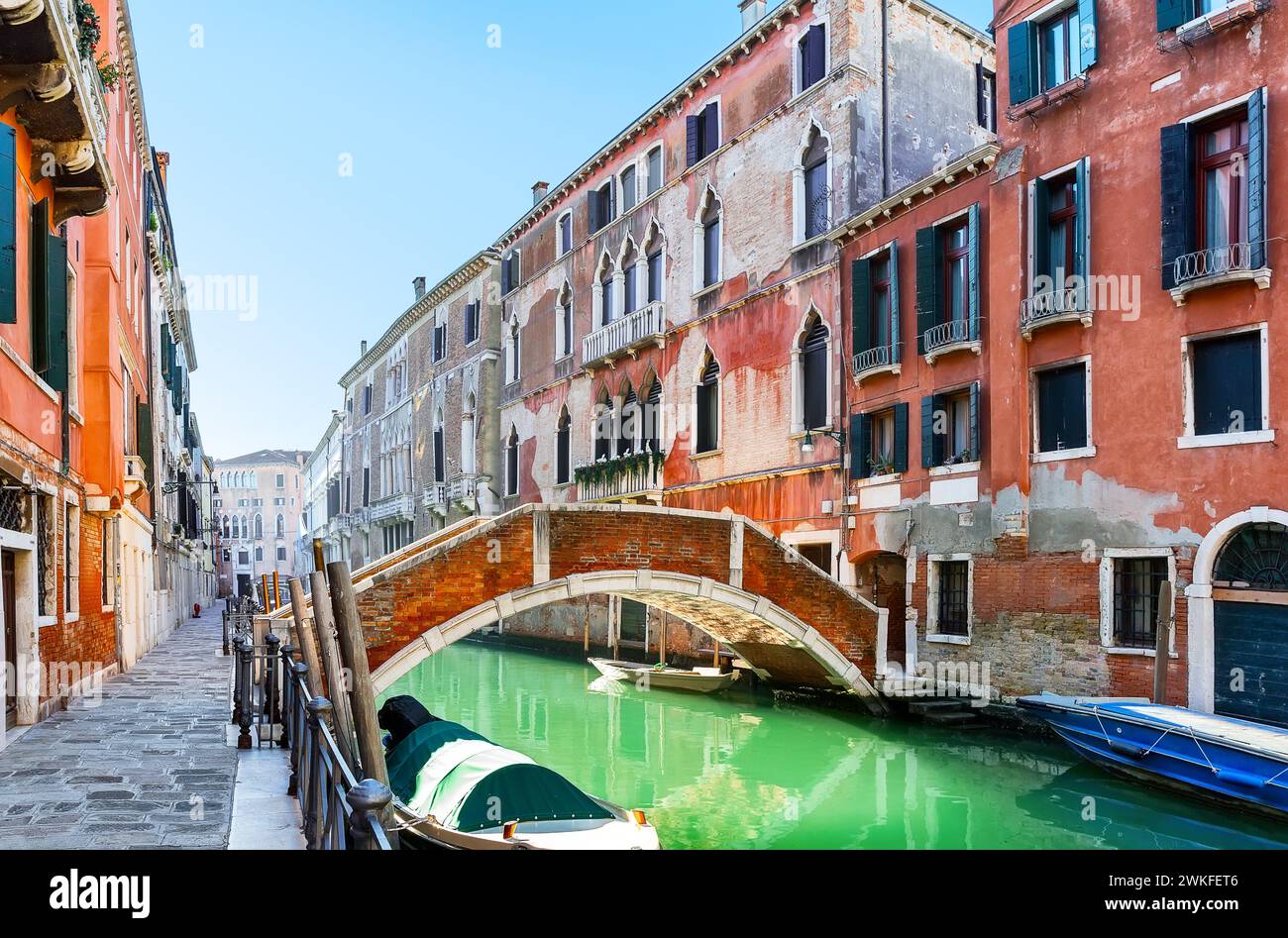 Traditional canal street with boats and colorful facades of old houses ...