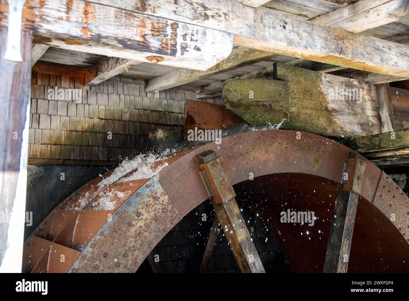 A metal water wheel that is driven by water. The water comes from a ...