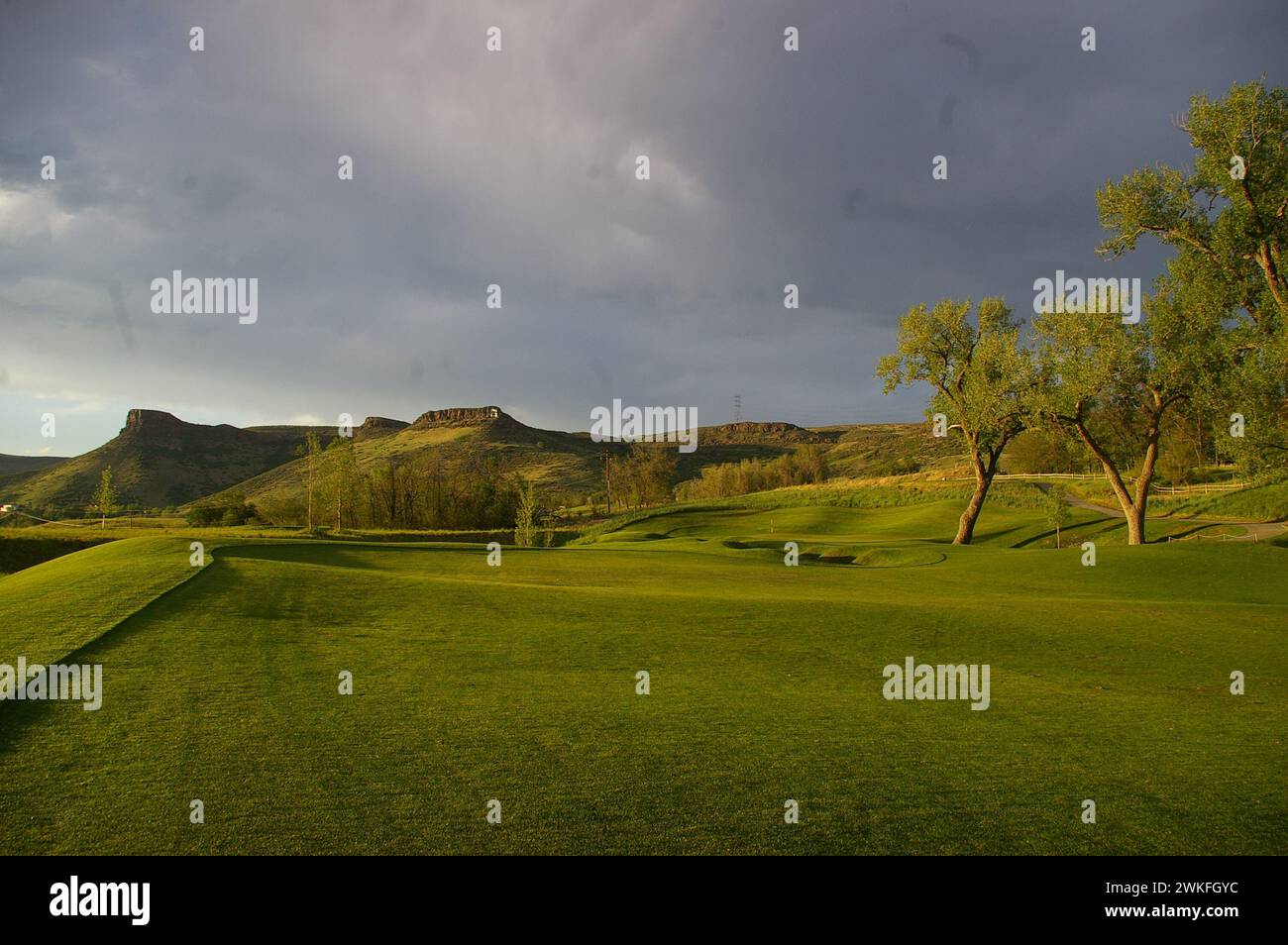 The Fossil Trace Golf course under cloudy skies, mountains afar ...