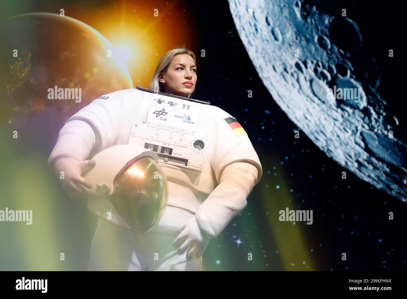 Eine Hostess posiert in einem Raumanzug am Stand des DLR auf der ...