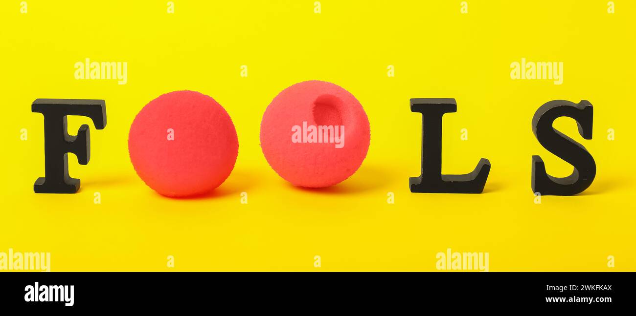 Word FOOLS made of letters and clown noses on yellow background. April ...