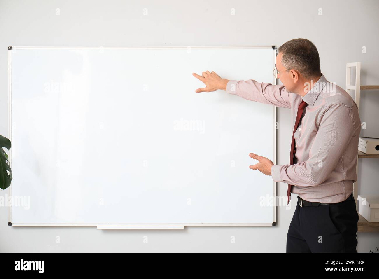 Male teacher pointing at flipboard in classroom Stock Photo - Alamy