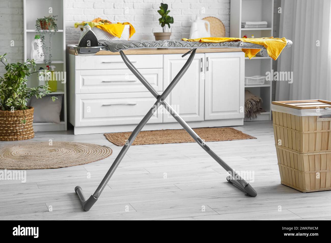 Interior of laundry room with ironing board and counters Stock Photo ...