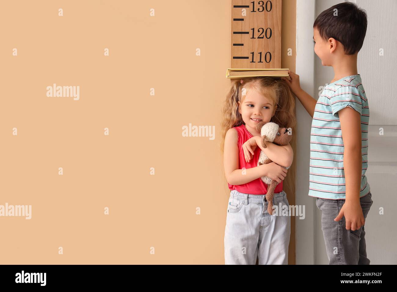 Cute little kids measuring height near wooden stadiometer Stock Photo ...