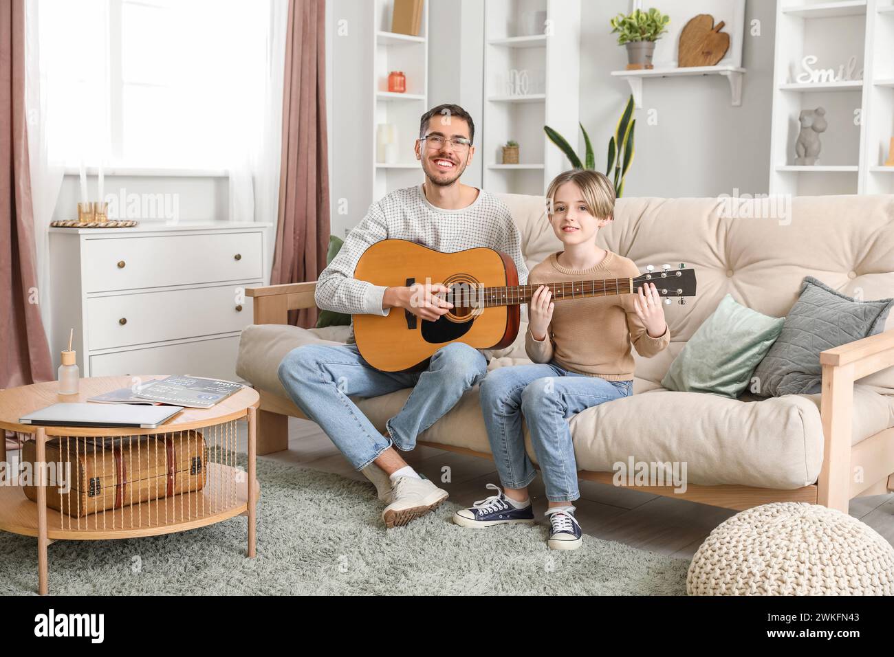 Private music teacher giving guitar lessons to little boy in living ...